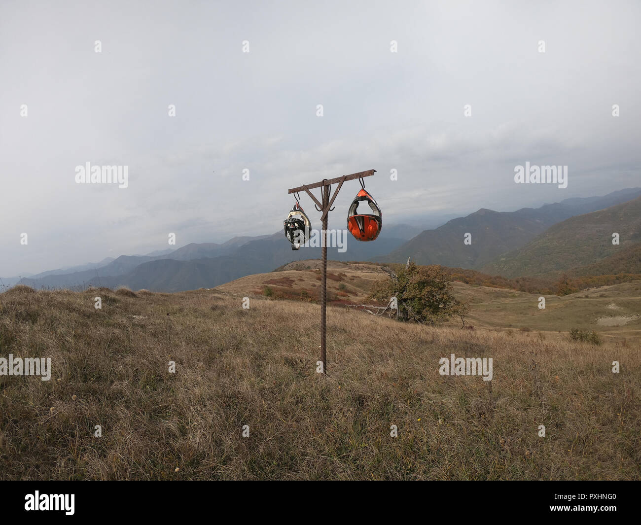 Motorcycle helmets hanging on the mountain on an iron hanger for ...