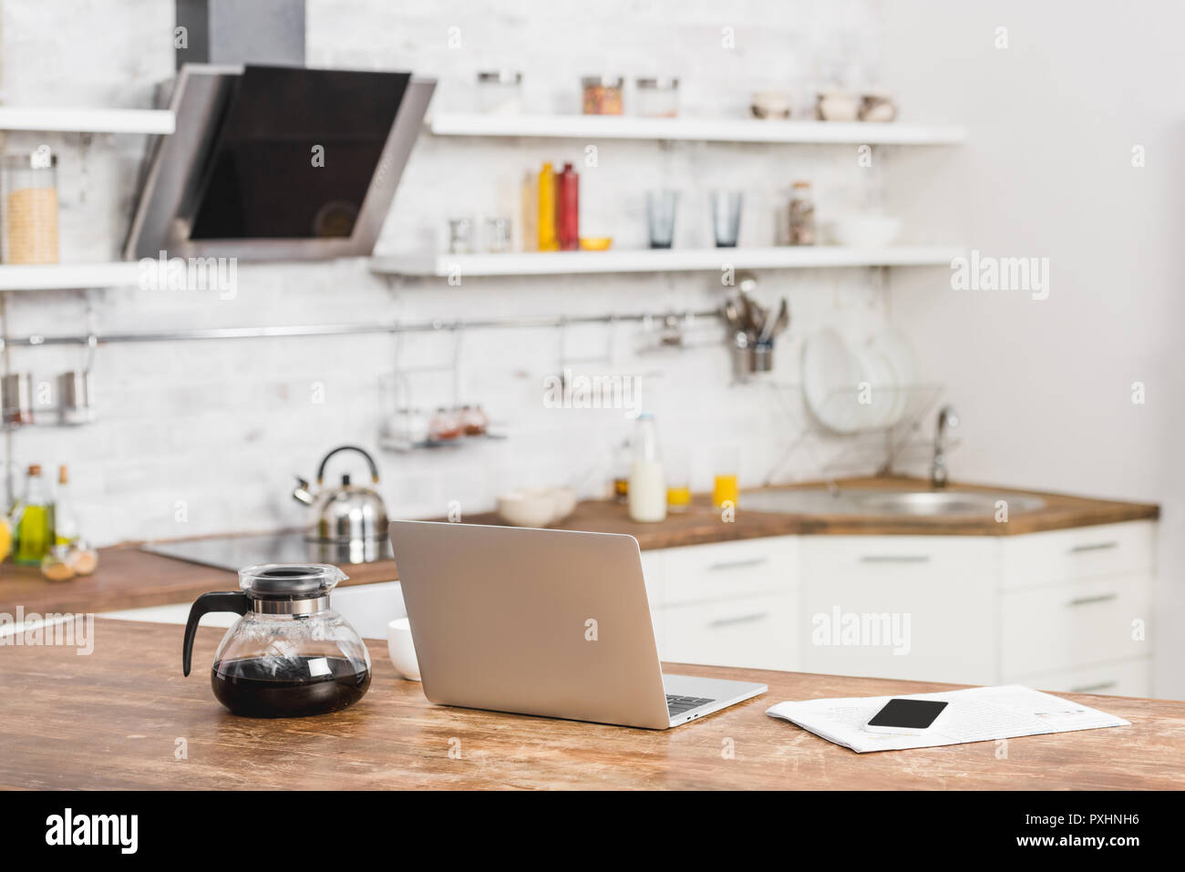 laptop, smartphone and coffee pot on kitchen counter Stock Photo - Alamy