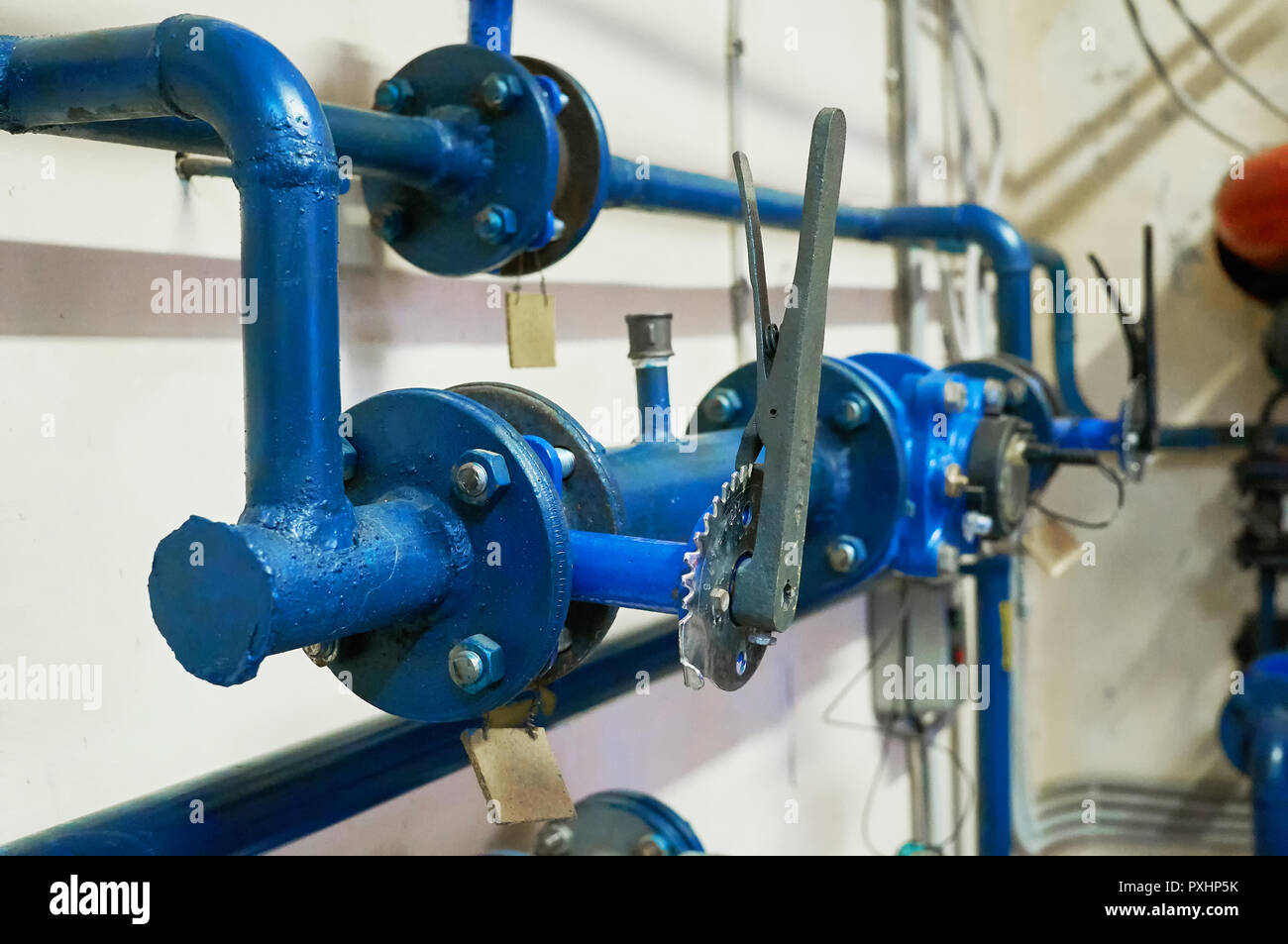 Gate valves installed on pipes painted in blue. Industrial background ...