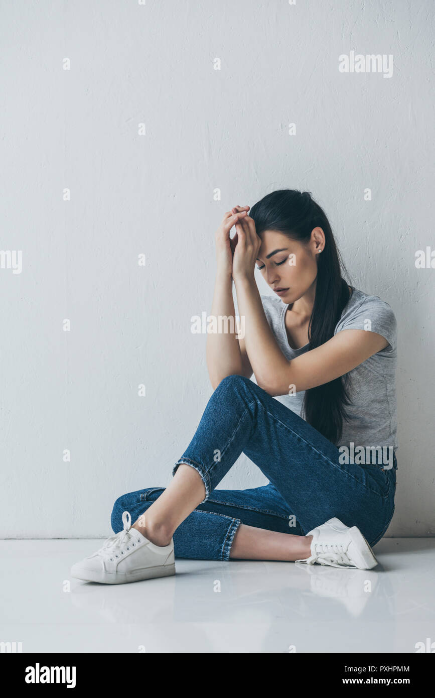 full length view of sad depressed young woman sitting on floor Stock ...