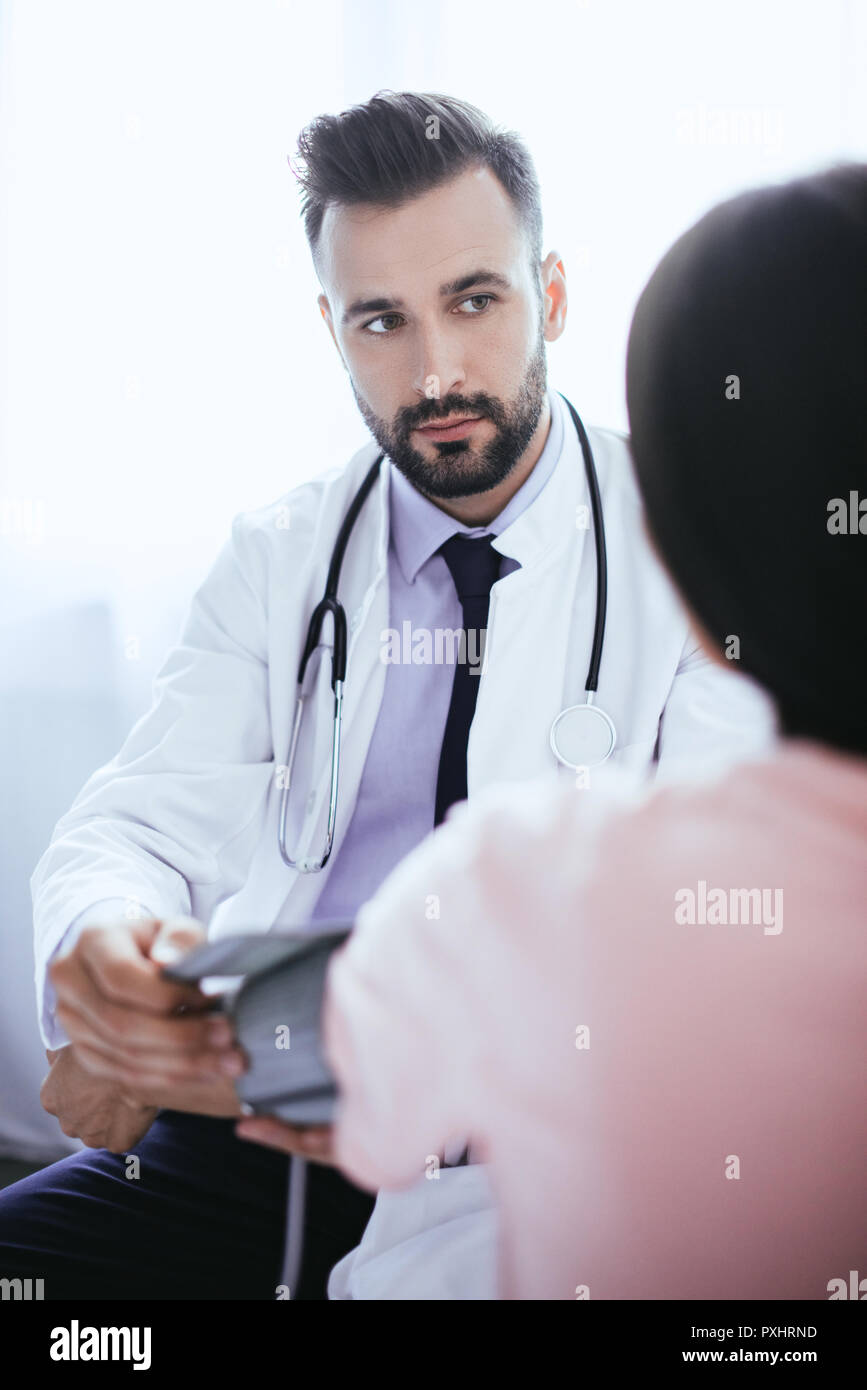 Handsome doctor listening hi-res stock photography and images - Alamy