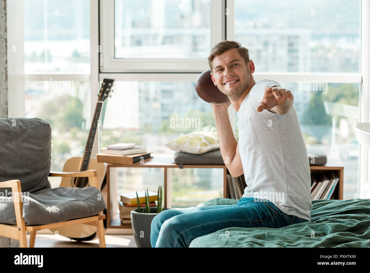 smiling man throwing rugby ball in hand at home Stock Photo - Alamy