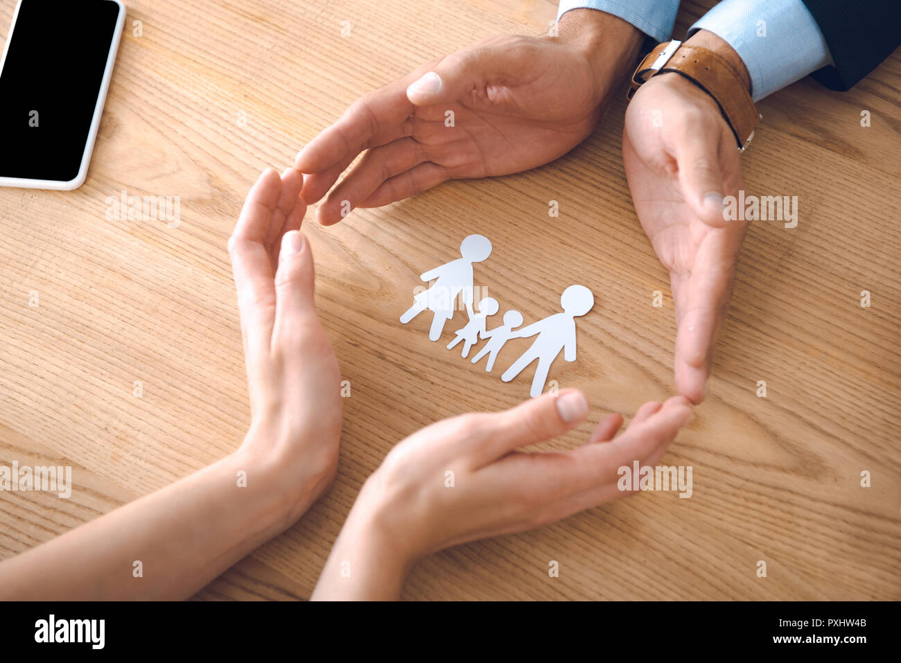 partial view of insurance agents and female hands with family paper ...
