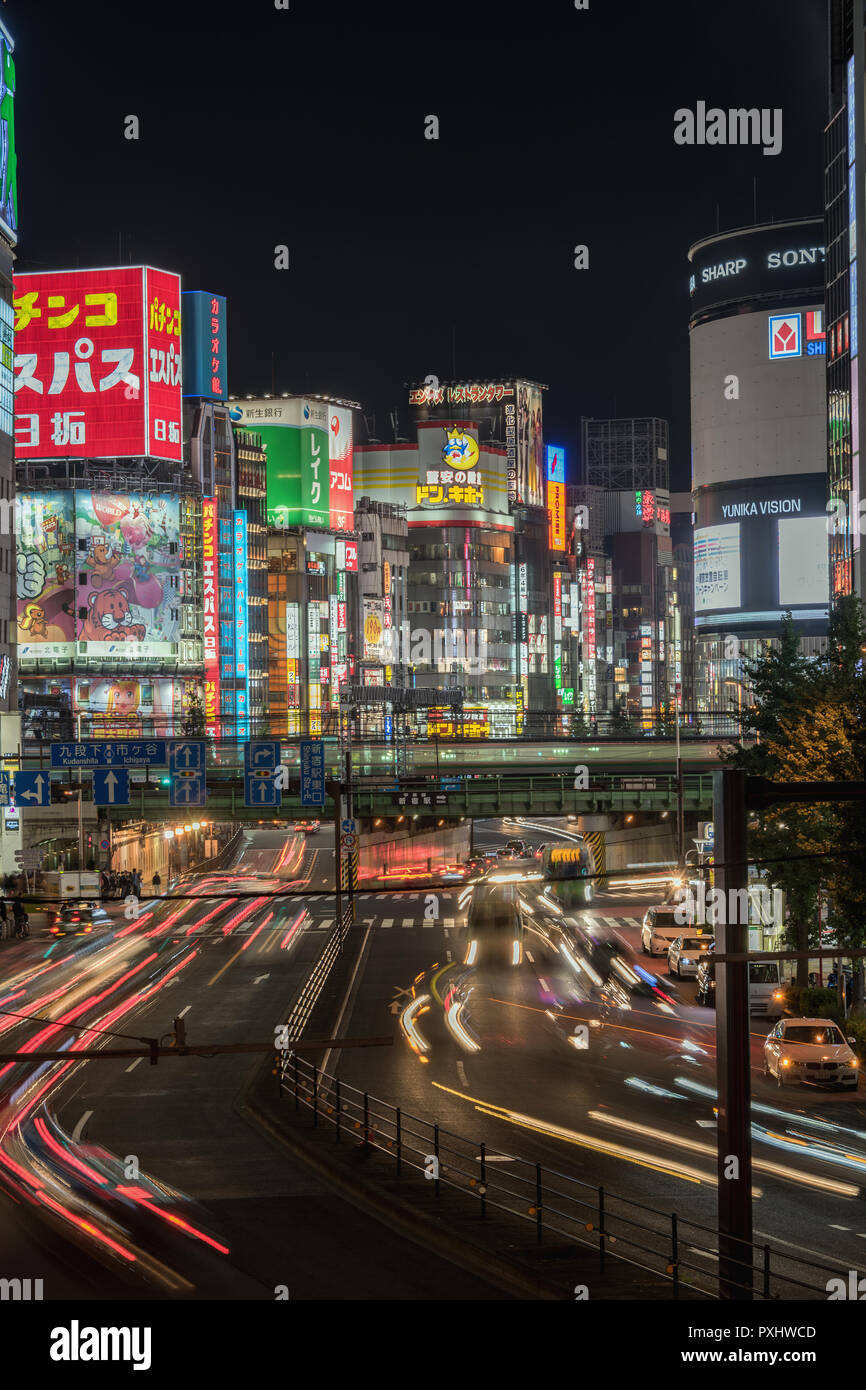 Shinjuku traffic and street lights with speeding train on overpass ...
