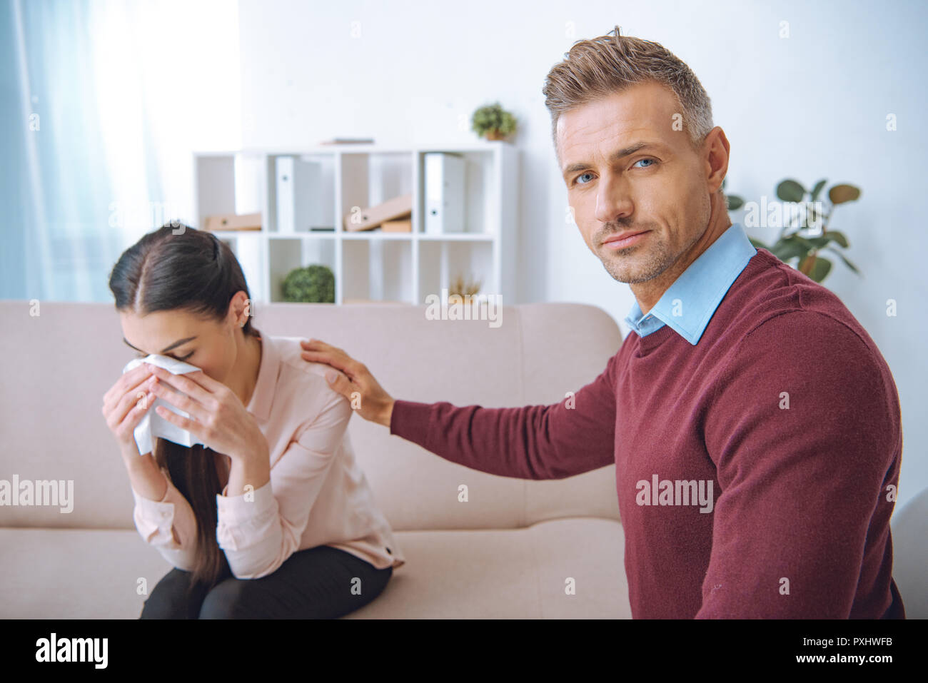 psychotherapist supporting crying patient and looking at camera Stock ...