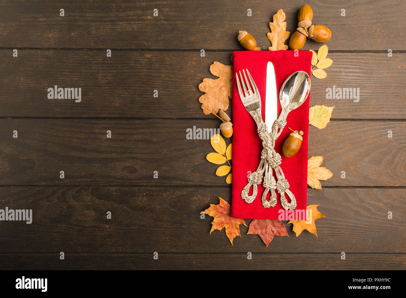 Autumn thanksgiving table with tableware and red tissue over wooden ...