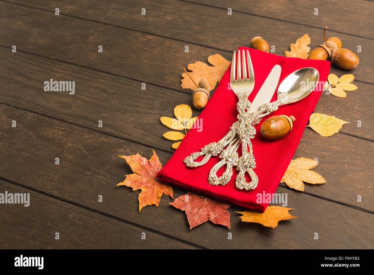 Autumn thanksgiving table with tableware and red tissue over wooden ...