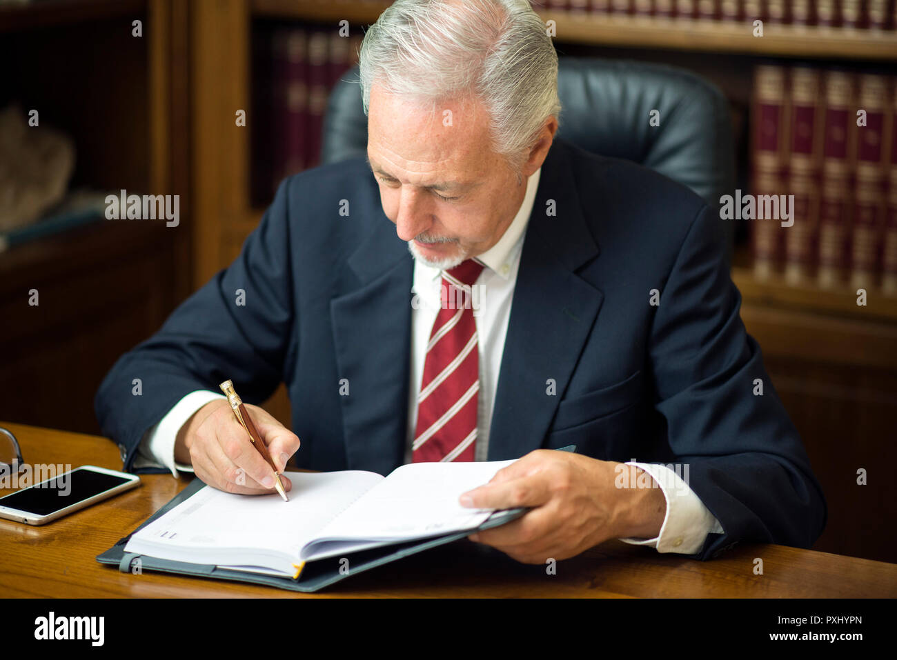 Businessman writing a note in his office Stock Photo - Alamy