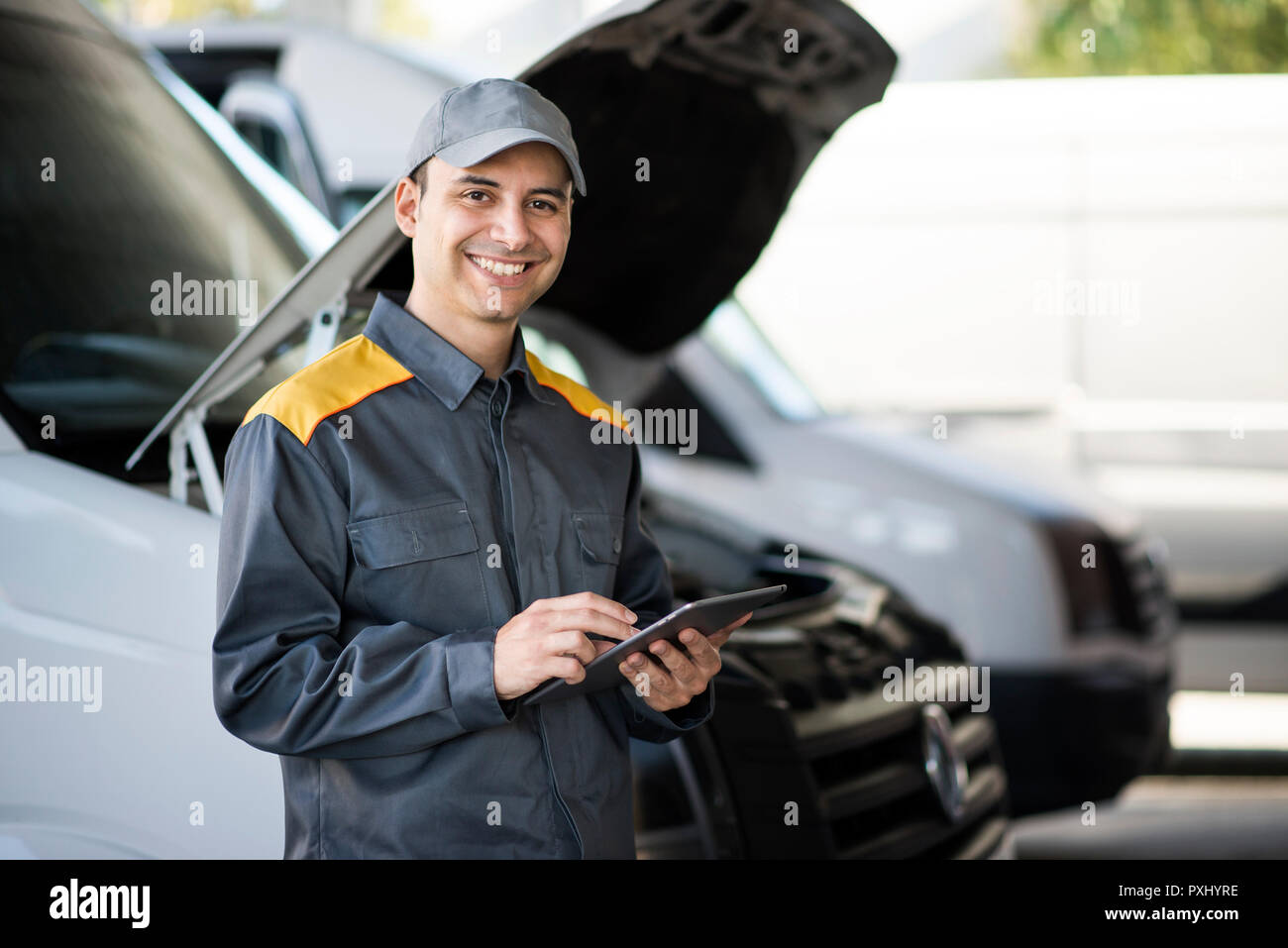 Mechainc using a tablet in front of a van Stock Photo - Alamy