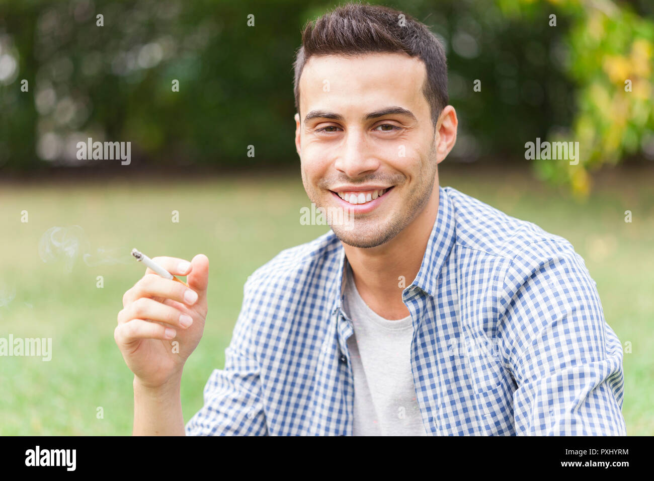 Man smoking a cigarette outdoors Stock Photo - Alamy
