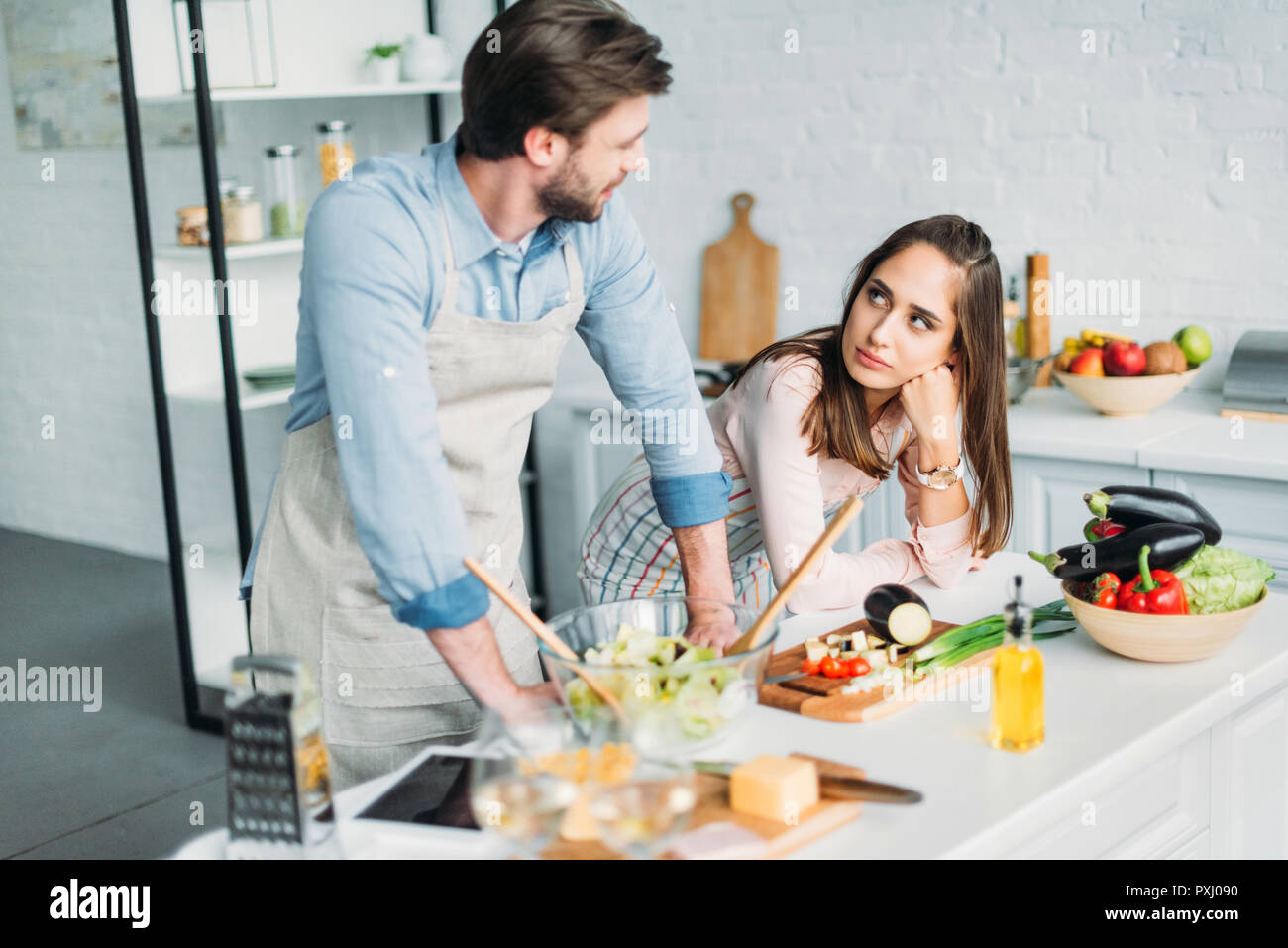 couple looking at each other at kitchen counter Stock Photo - Alamy