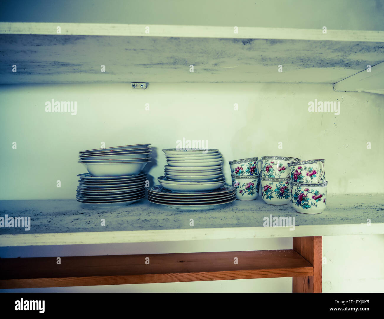 Cups and plates in old cupboard Stock Photo - Alamy