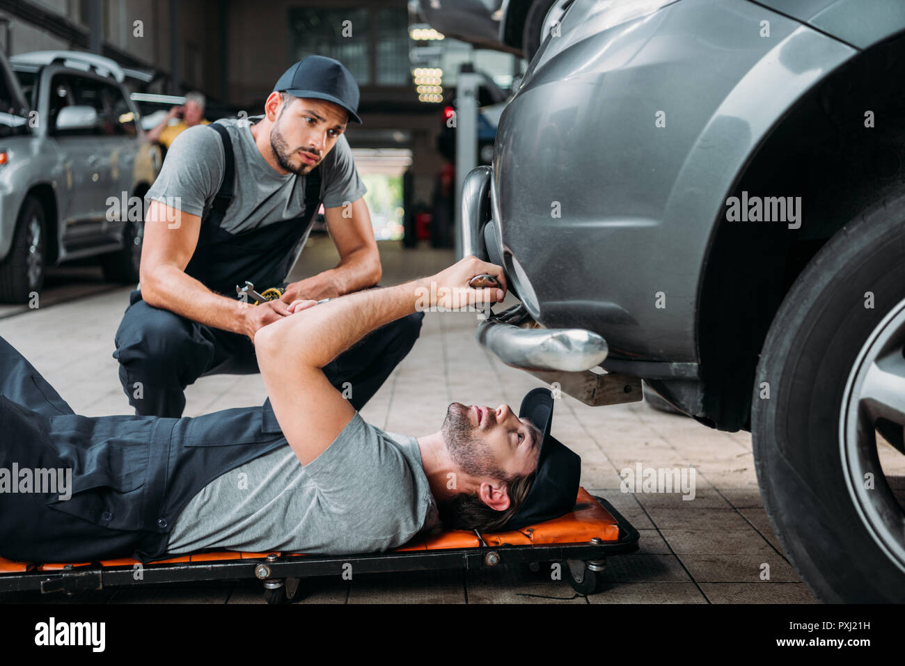 professional auto mechanics repairing car in workshop Stock Photo - Alamy