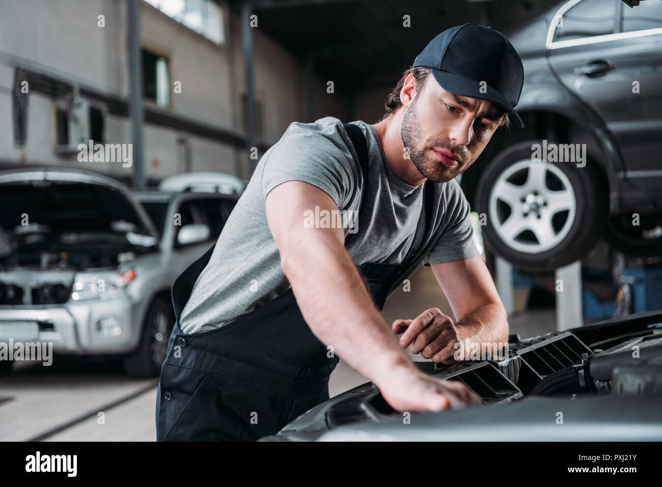 professional auto mechanic working with car in repair shop Stock Photo ...