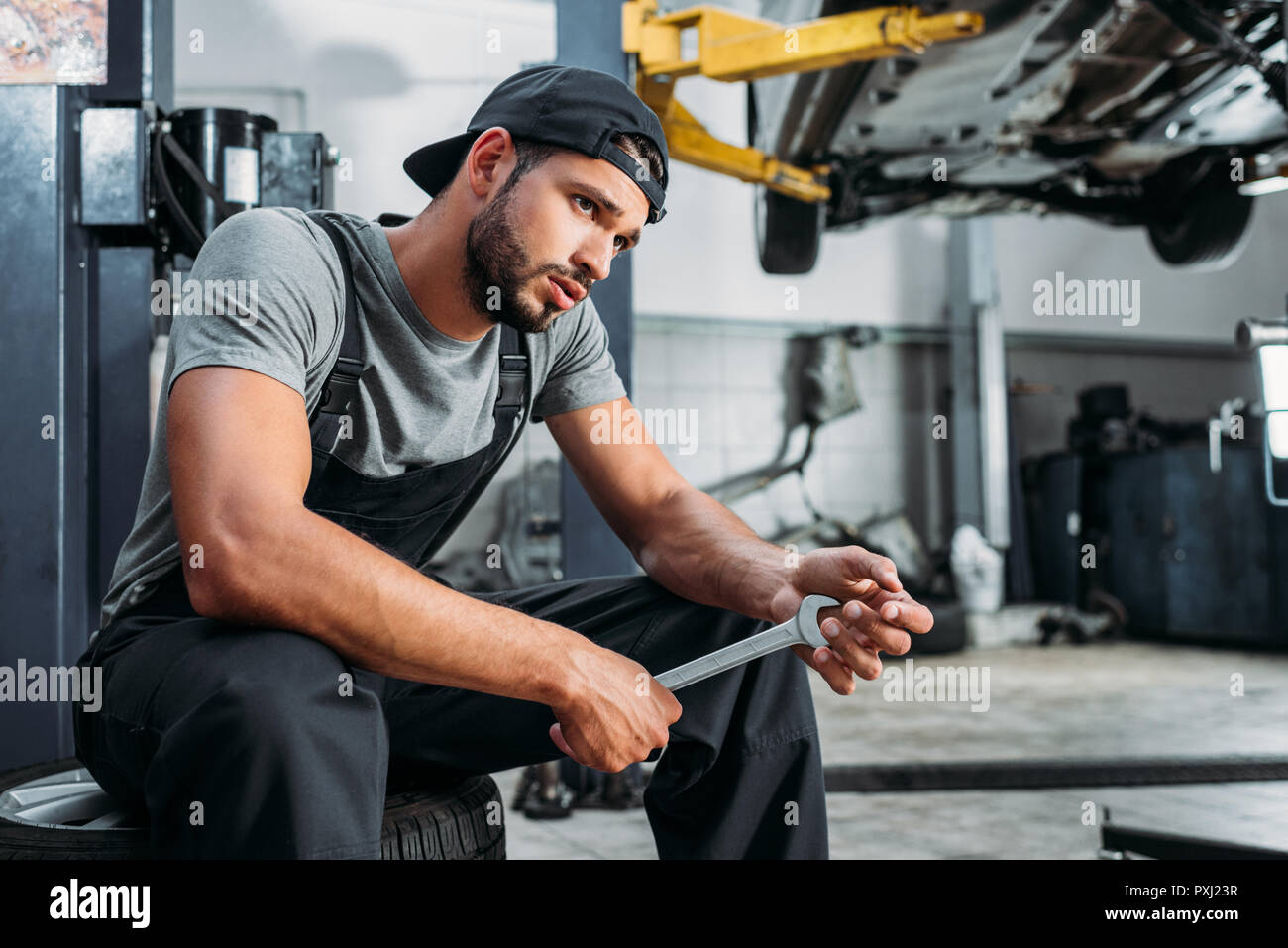 Auto mechanic sitting holding hi-res stock photography and images - Alamy