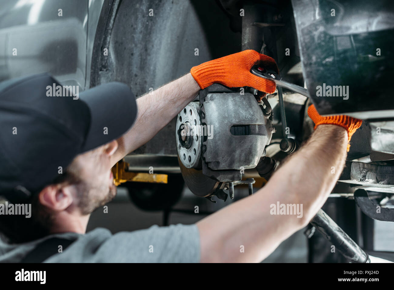 professional auto mechanic repairing car without wheel Stock Photo - Alamy