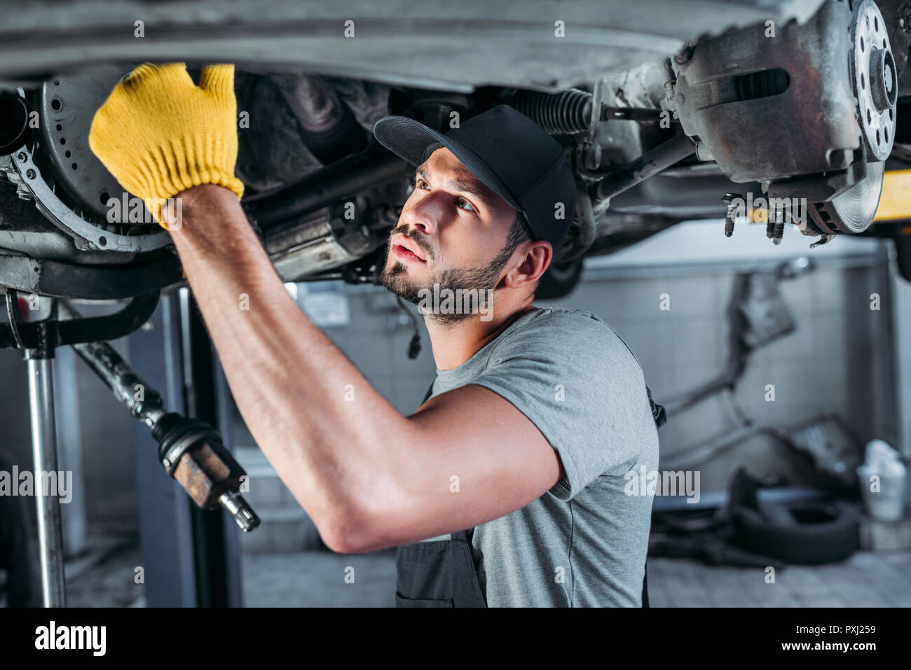 male mechanic fixing a car in auto repair shop Stock Photo - Alamy