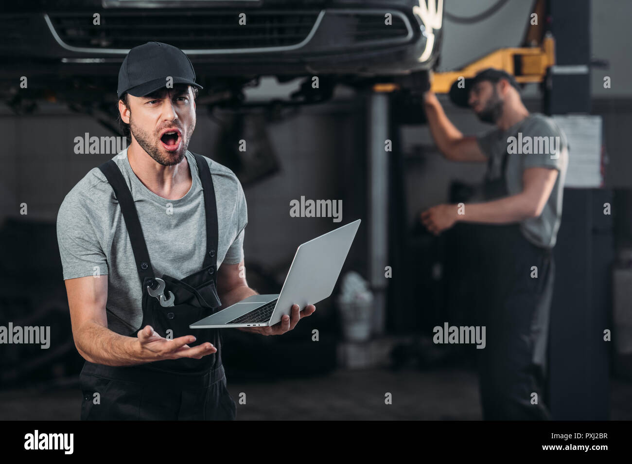 Mechanic using computer in automobile workshop hi-res stock photography ...