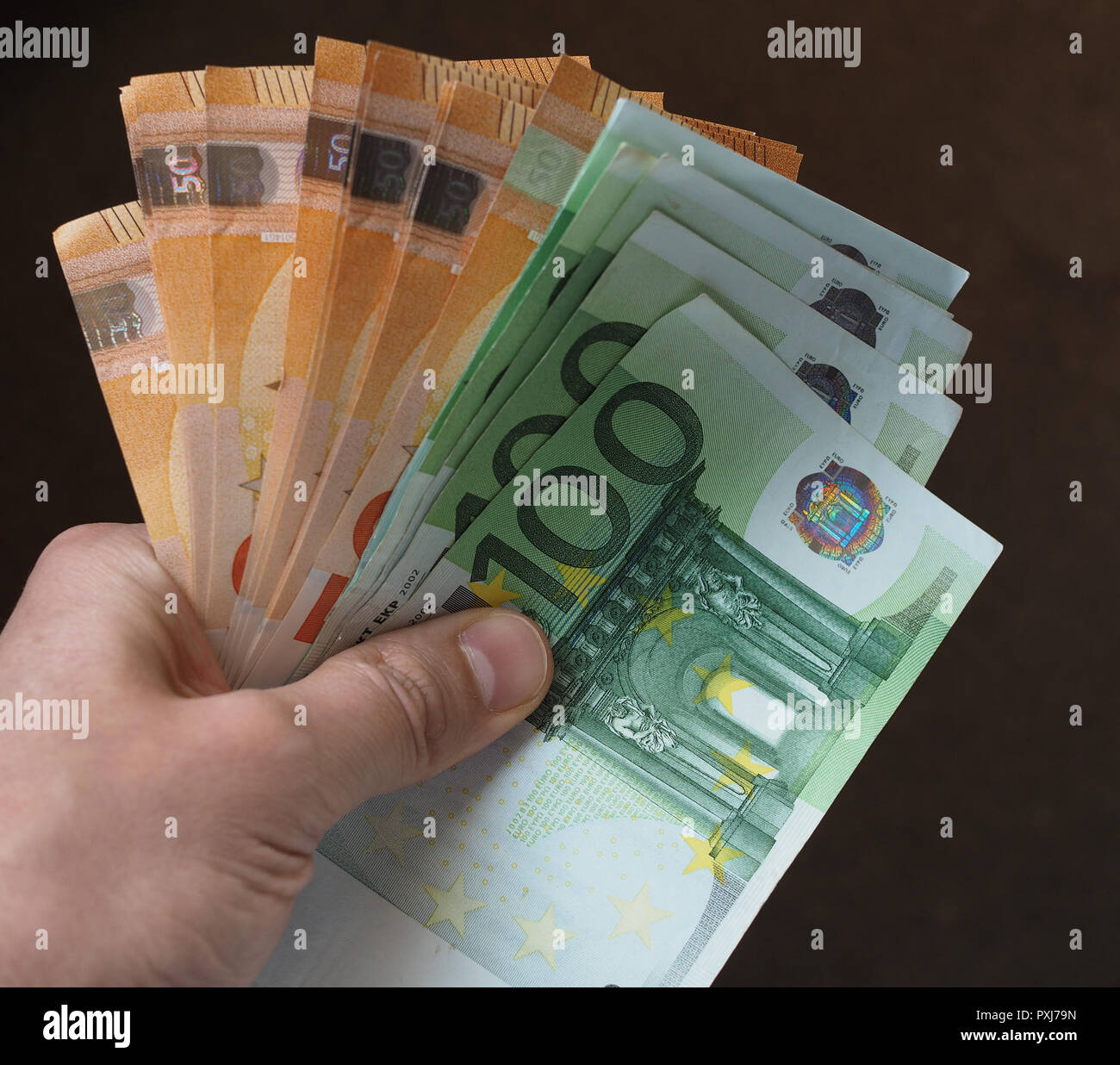 Hand holding and giving Euro banknotes money (EUR), currency of ...