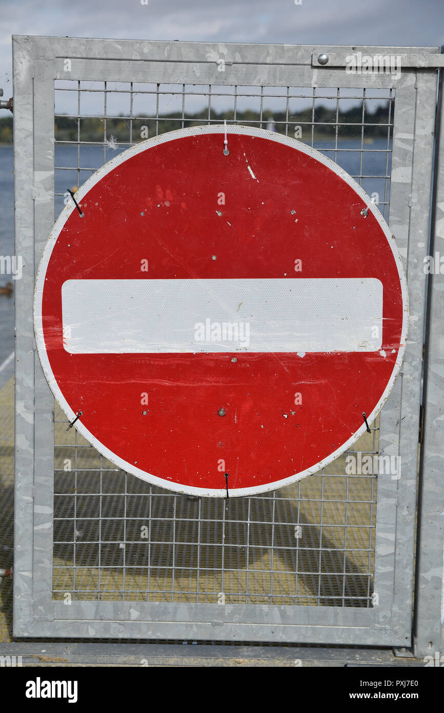 Circular No Entry sign with white bar on red background on a metal gate ...