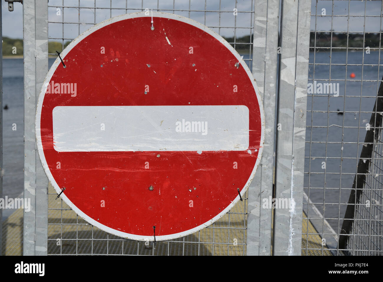 Circular No Entry sign with white bar on red background on a metal gate ...