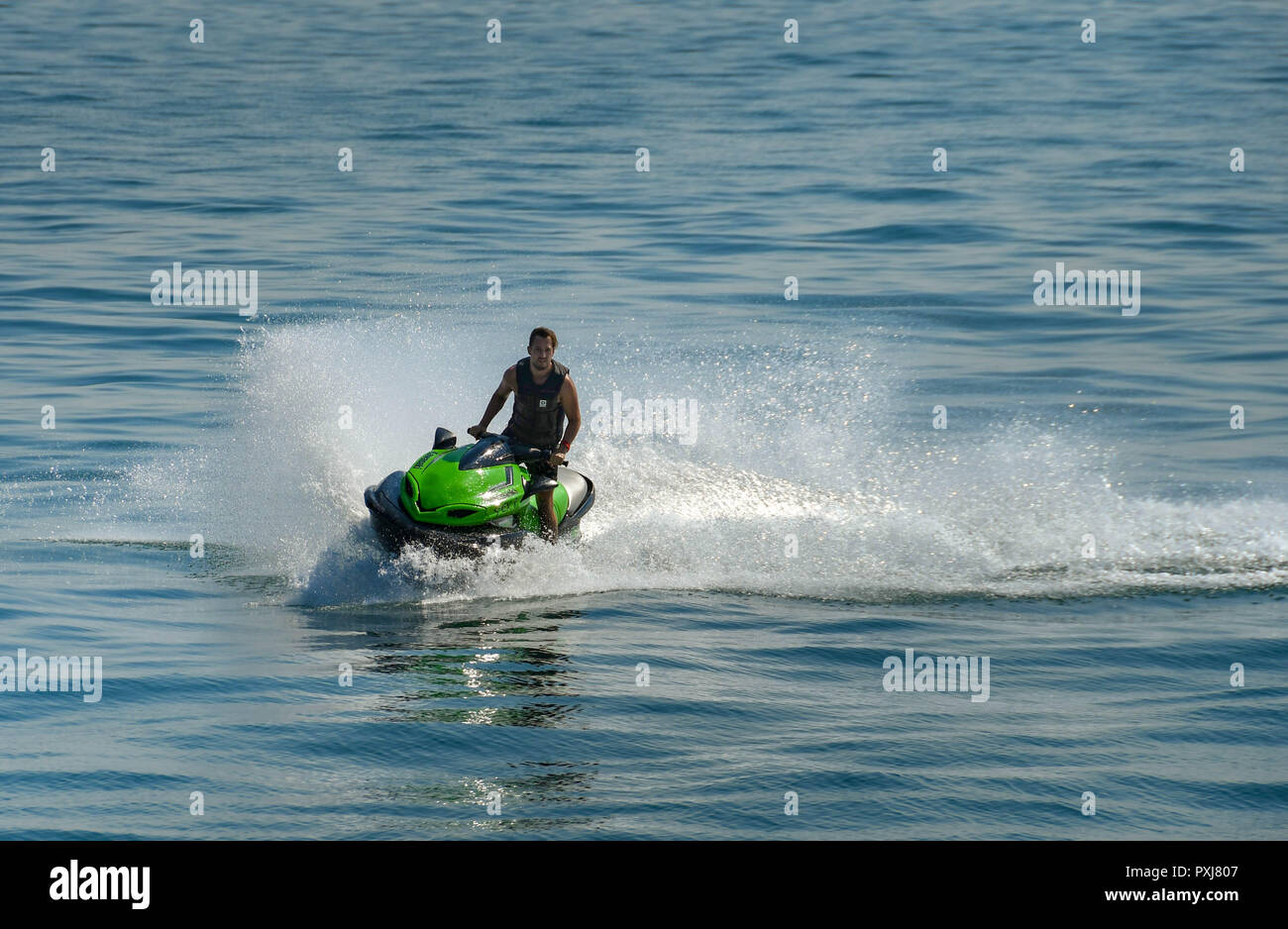 LAKE GARDA, ITALY - SEPTEMBER 2018: Person riding a fast jet ski ...
