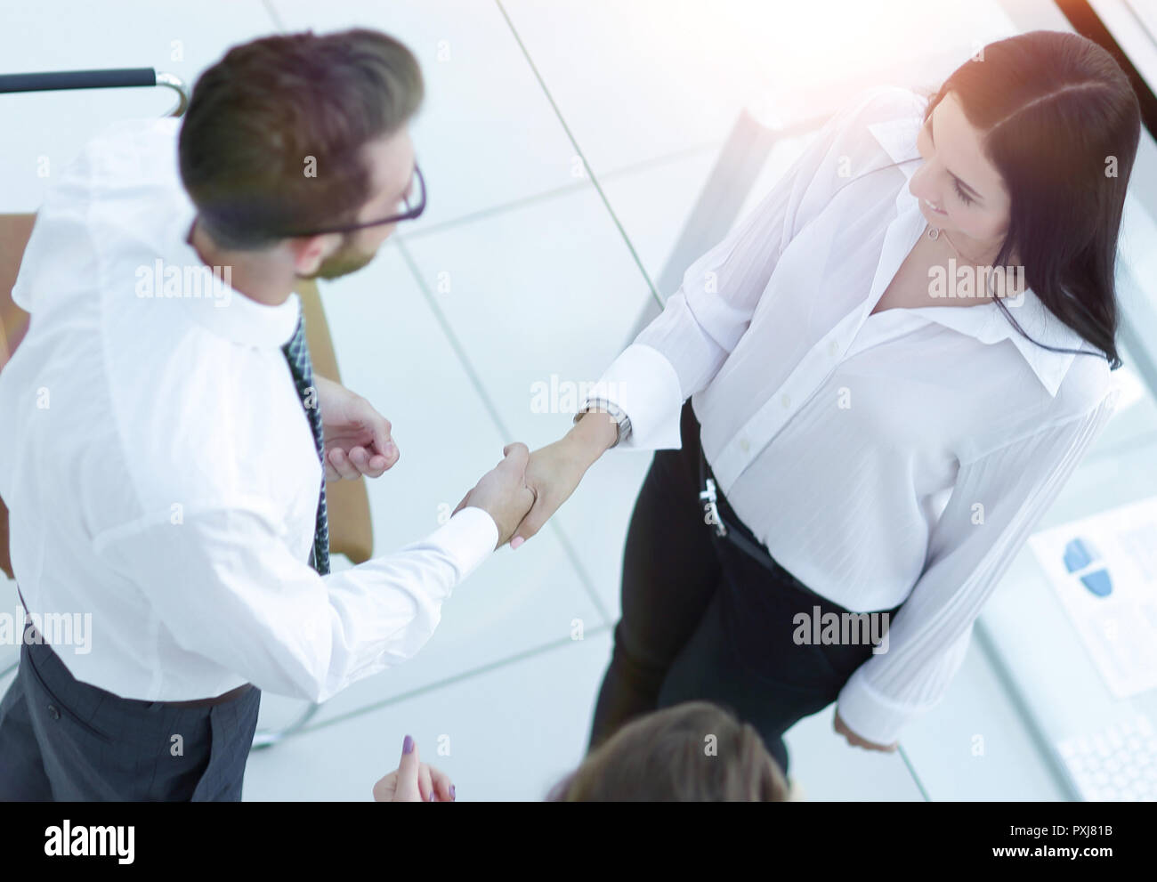 handshake manager and employee near the workplace. photo with copy ...
