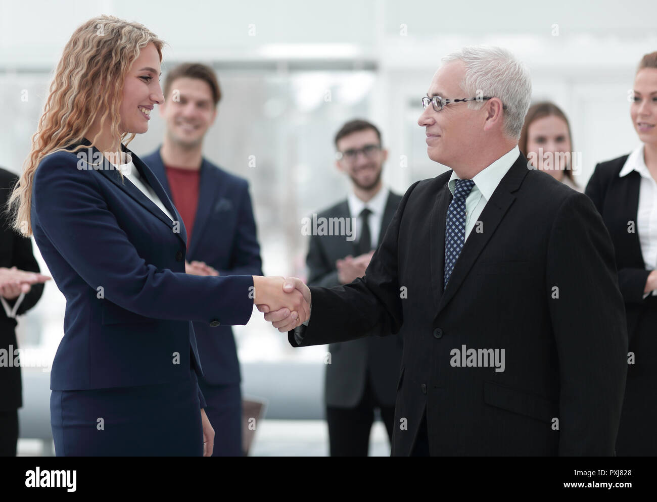 handshake serious businessman and business woman in the presence of a business team Stock Photo ...