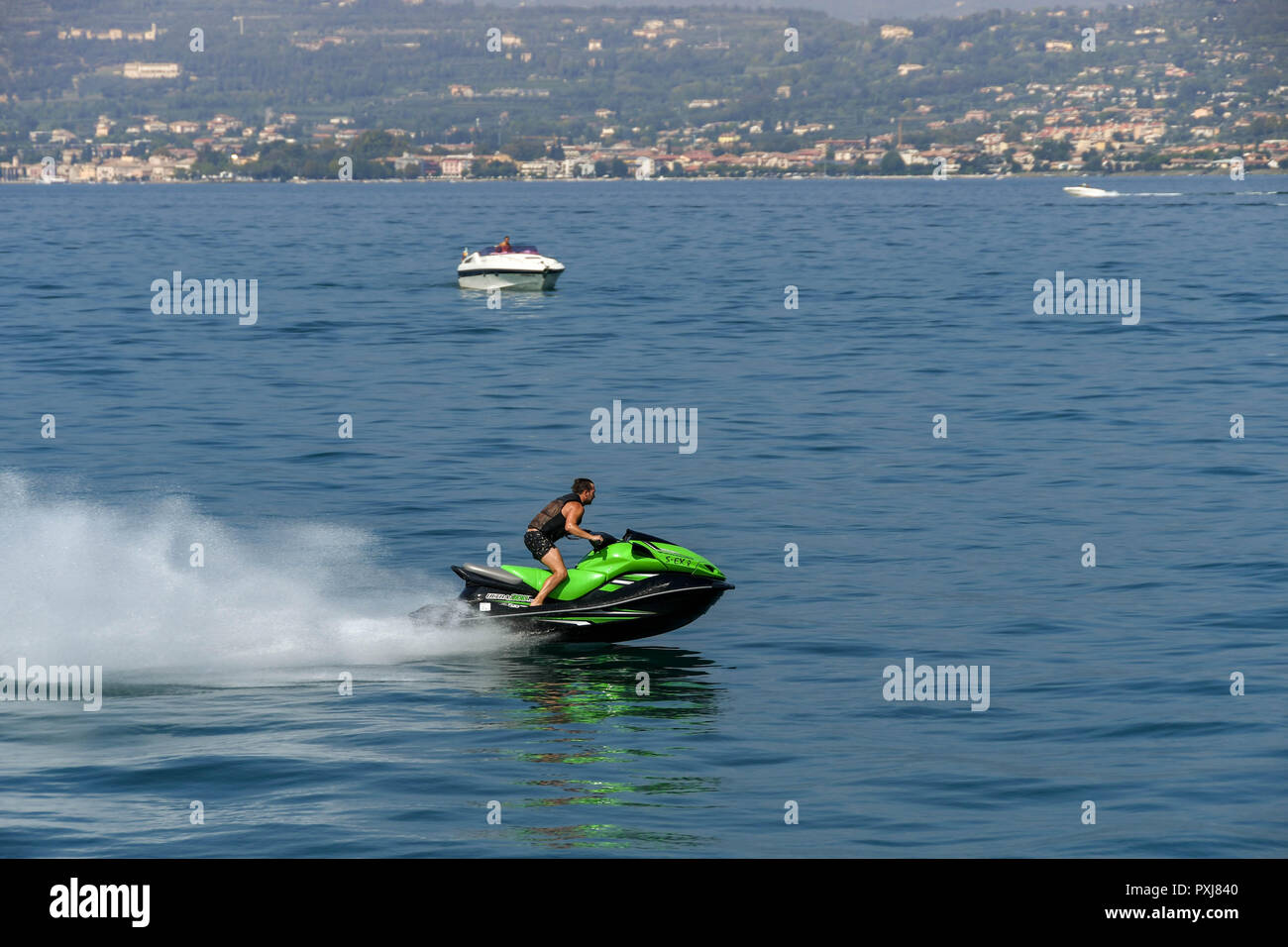 LAKE GARDA, ITALY - SEPTEMBER 2018: Person riding a fast jet ski ...