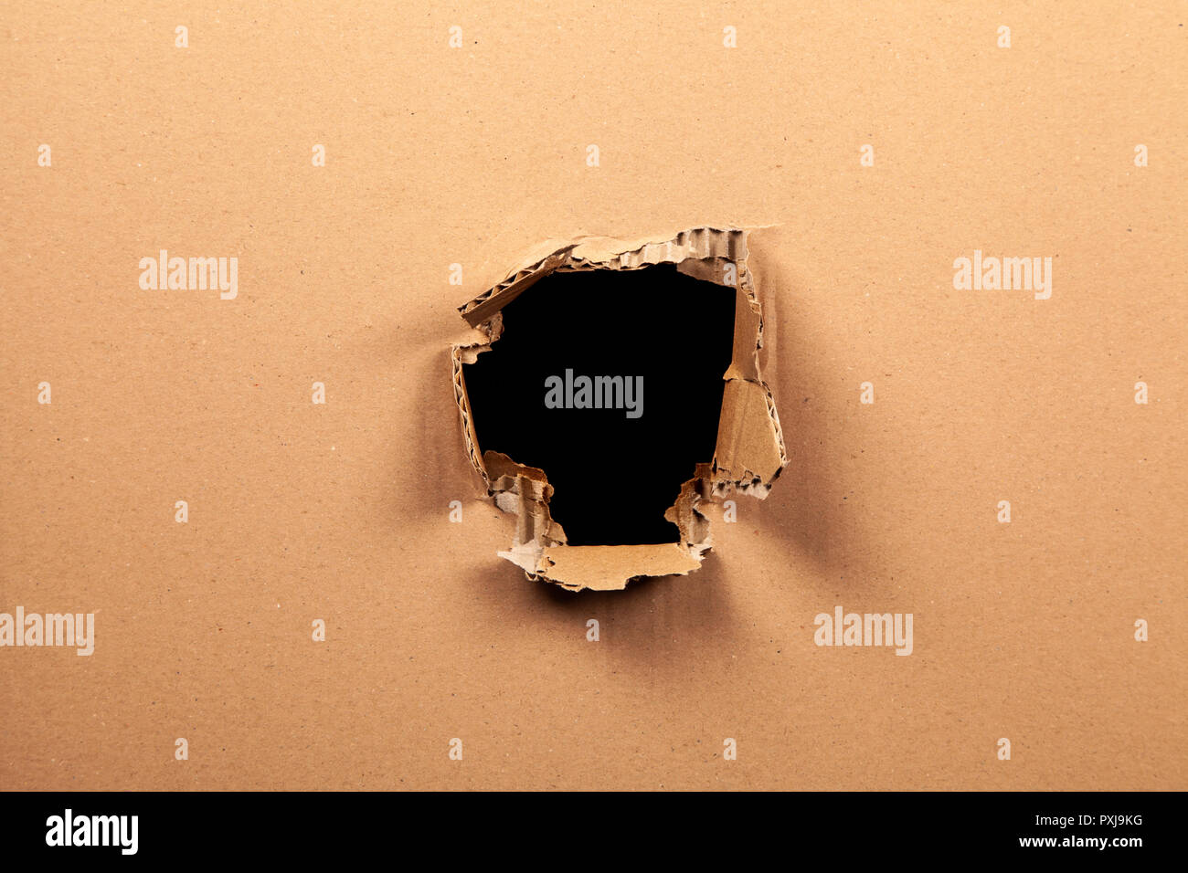 Cardboard with a hole, black background Stock Photo - Alamy