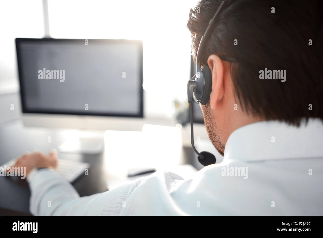 rear view.employee call center looking at the computer monitor.photo ...