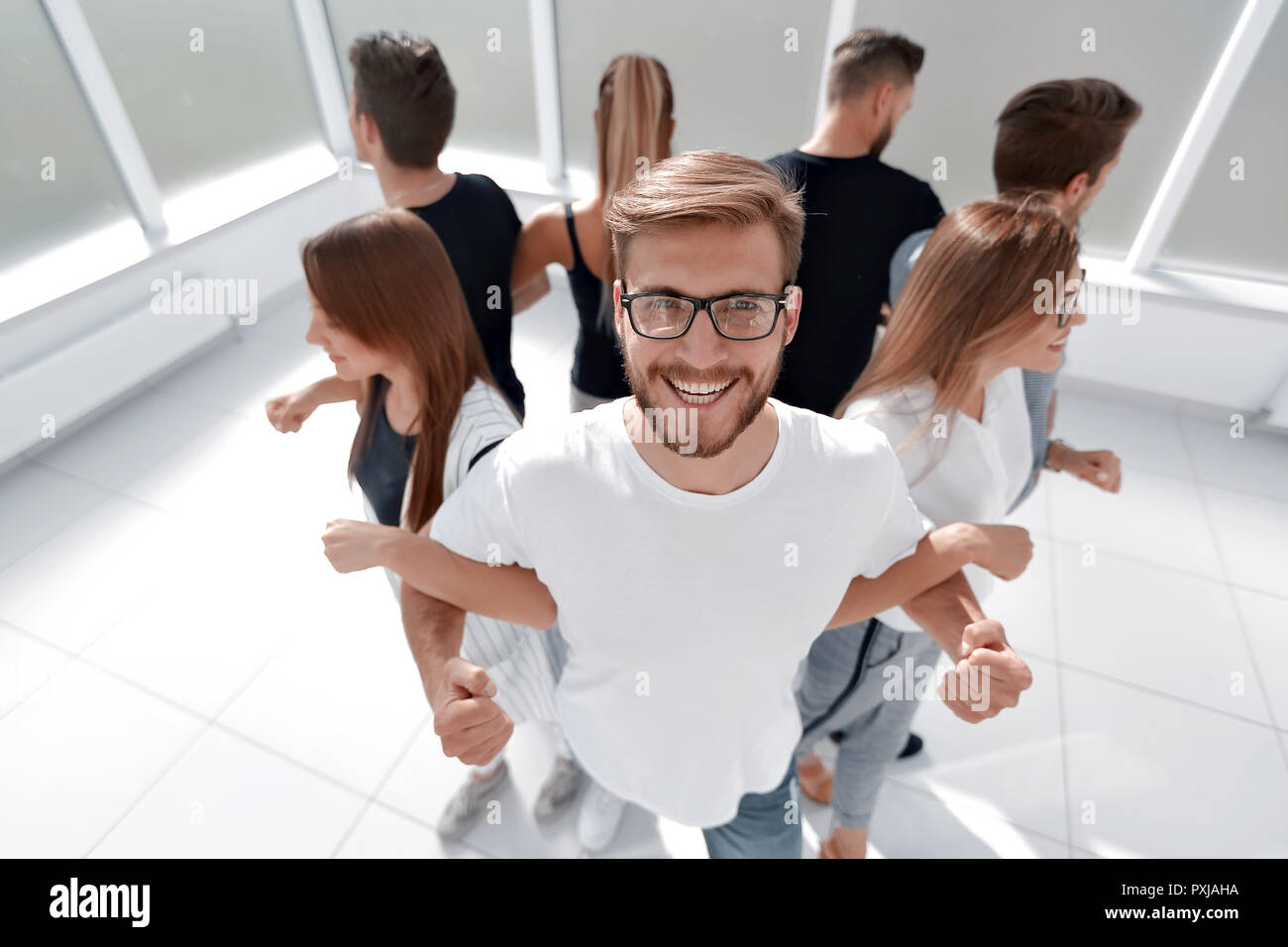 young man standing in a circle with a business team Stock Photo - Alamy