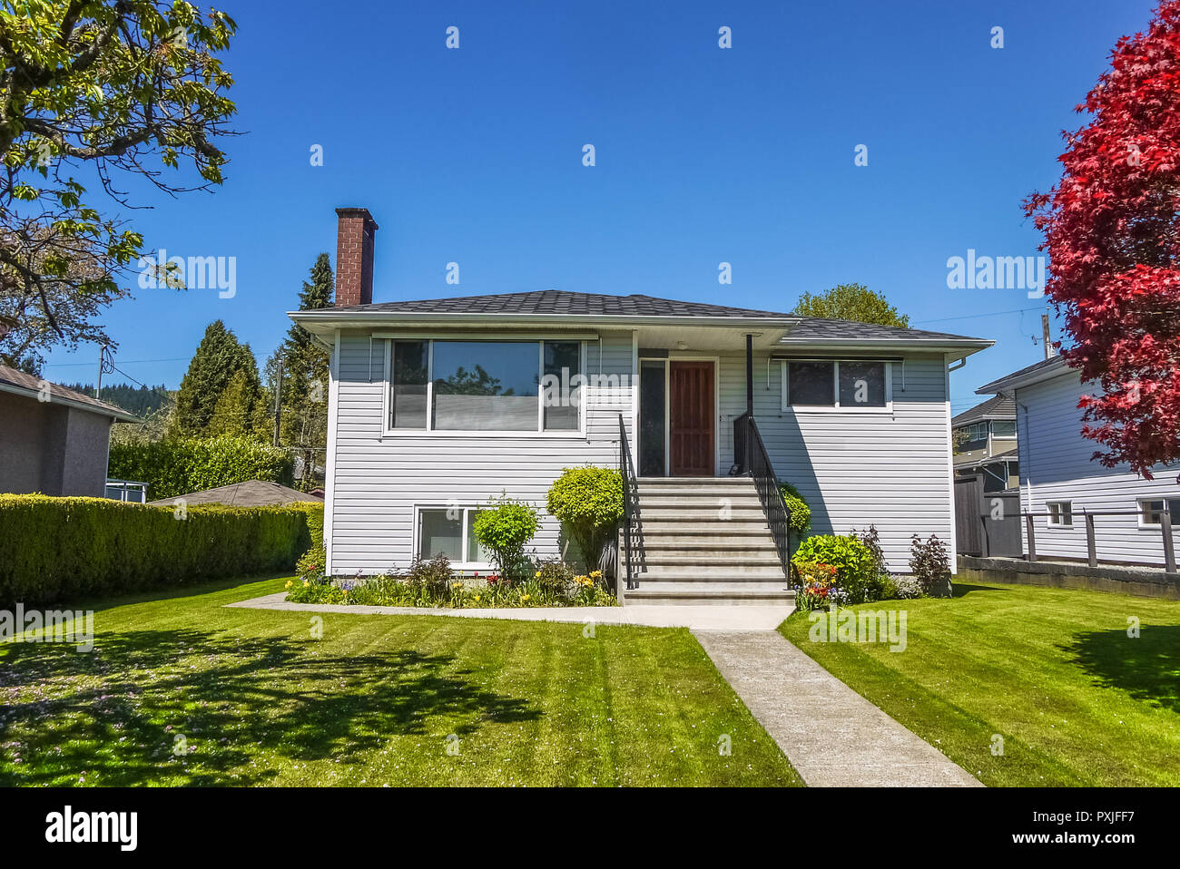 Old modest residential house with concrete pathway over the lawn front ...