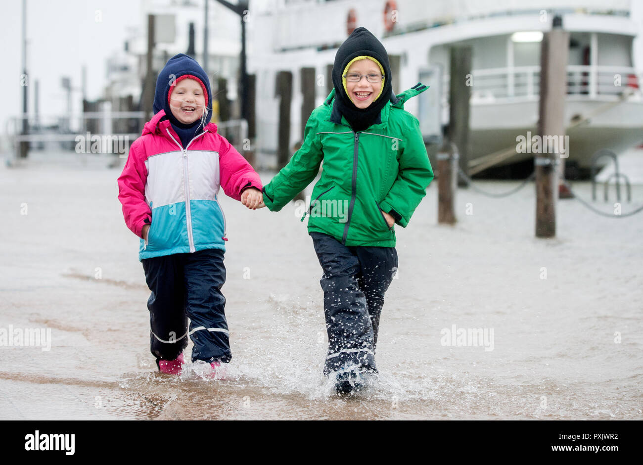 Harlesiel, Germany. 23rd Oct, 2018. Lea and Felix run in the harbour ...