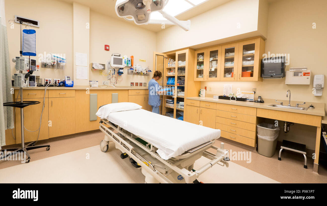 A hospital emergency room nurse stocks a cabinet with trauma supplies ...