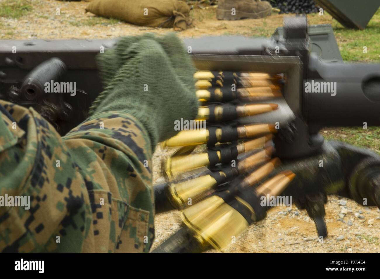 Fifty caliber machine gun rounds feed into an M2 .50-caliber Browning ...