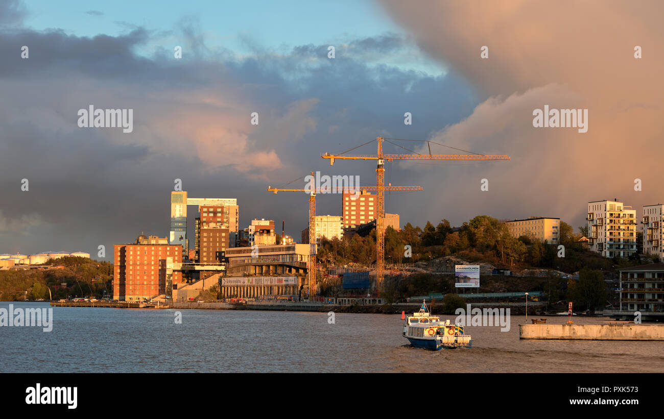 Sunlit Kvarnholmen below dramatic cloudy sky in an evening Stockholm ...