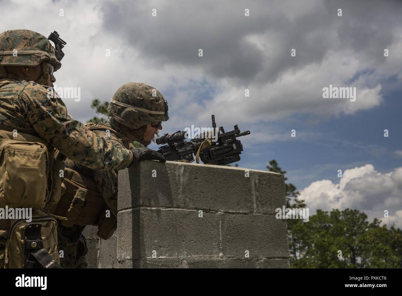 A Marine steadies an M320 grenade launcher module mounted on an M4 ...