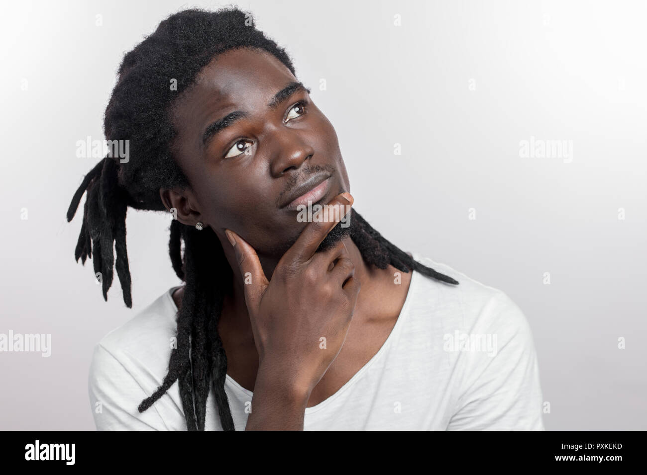 Thinking or dreaming african man with dreadlocks on white background ...