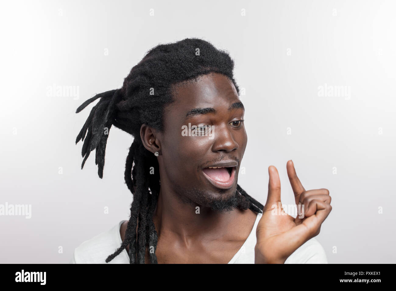 dark skinned man showing small thing while smiling and standing near ...