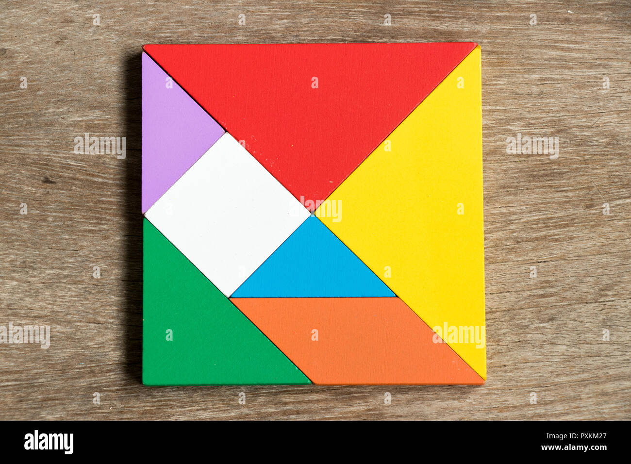 Colorful tangram puzzle in square shape on wood background Stock Photo ...