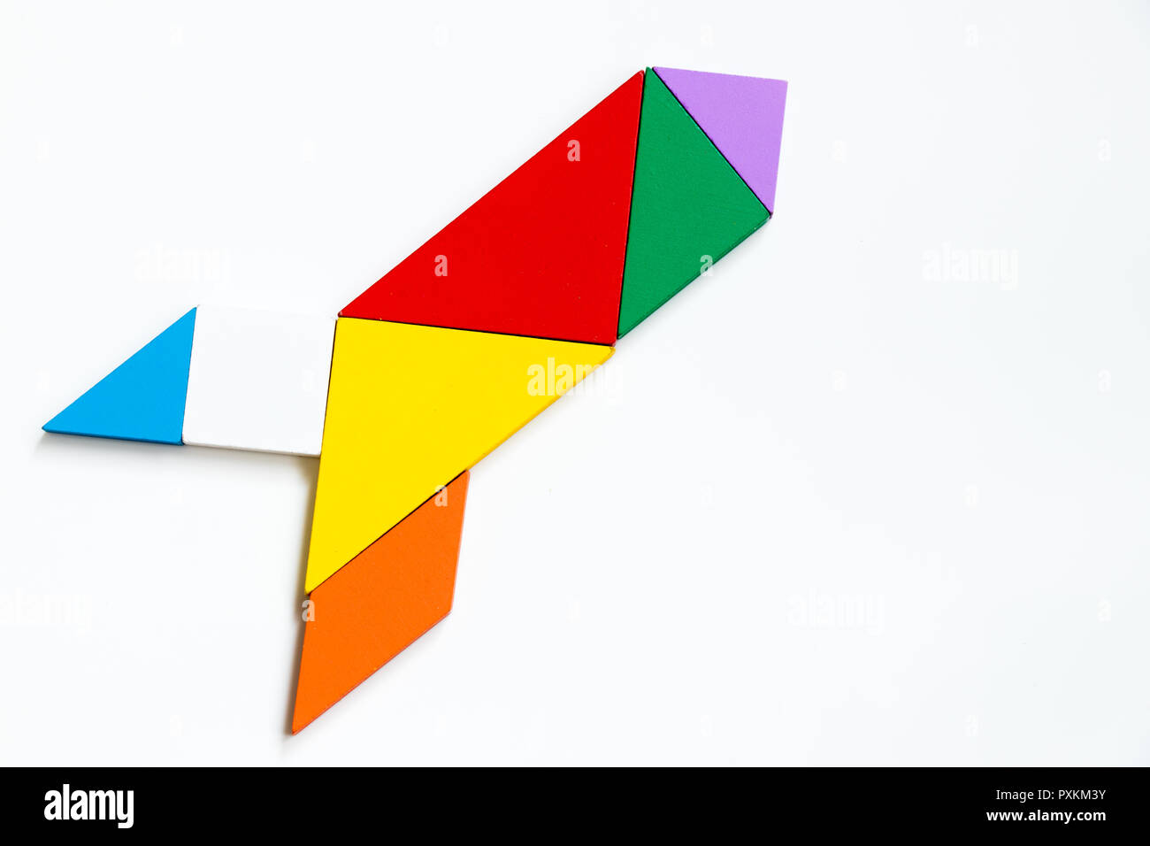 Colorful wood tangram puzzle in rocket or missile shape on white ...