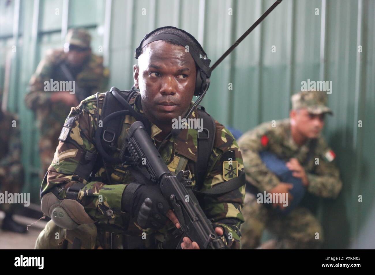 A member of the Trinidad and Tobago Defence Force observes a hallway ...