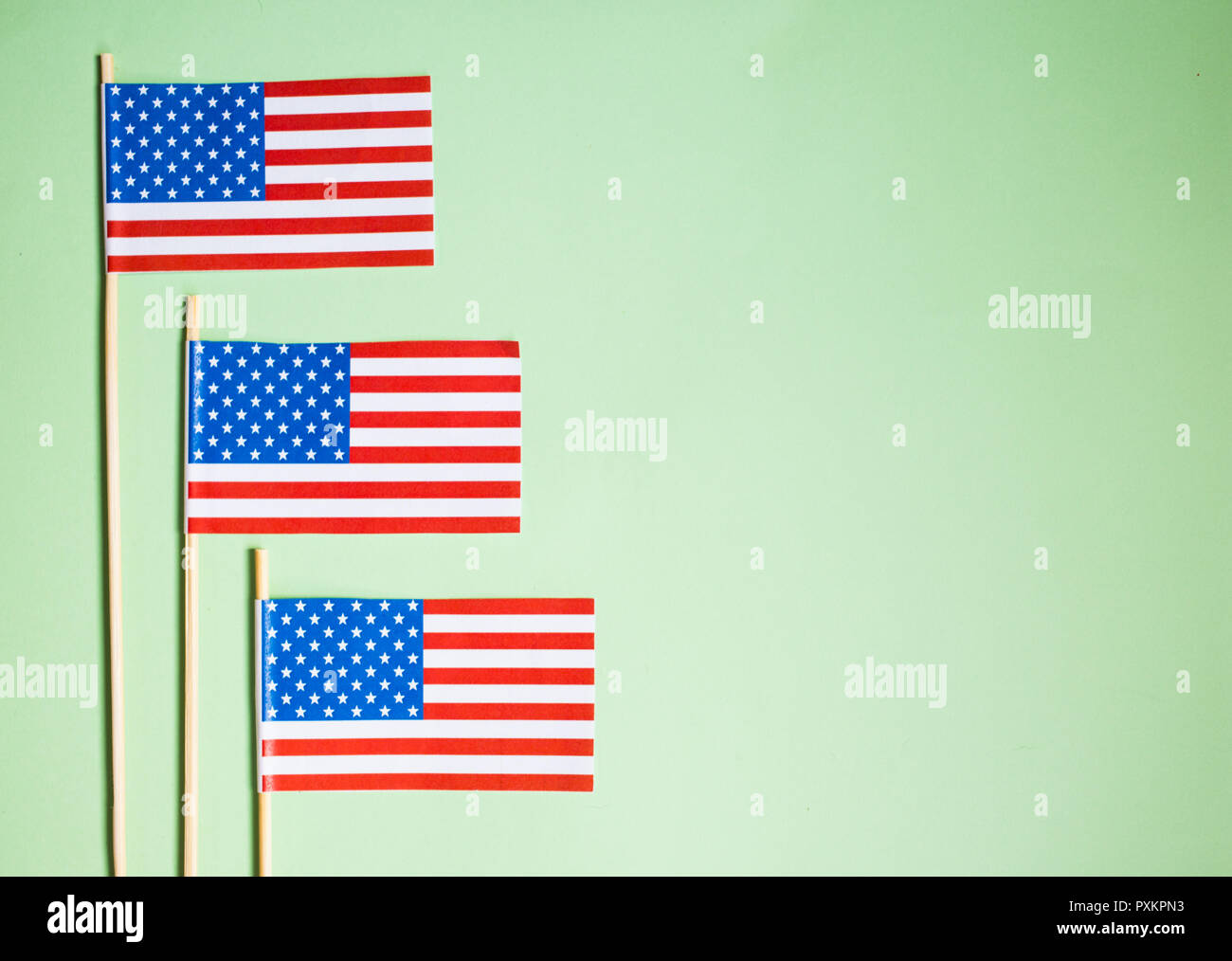 Miniature paper flag USA. American Flag on green background Stock Photo ...