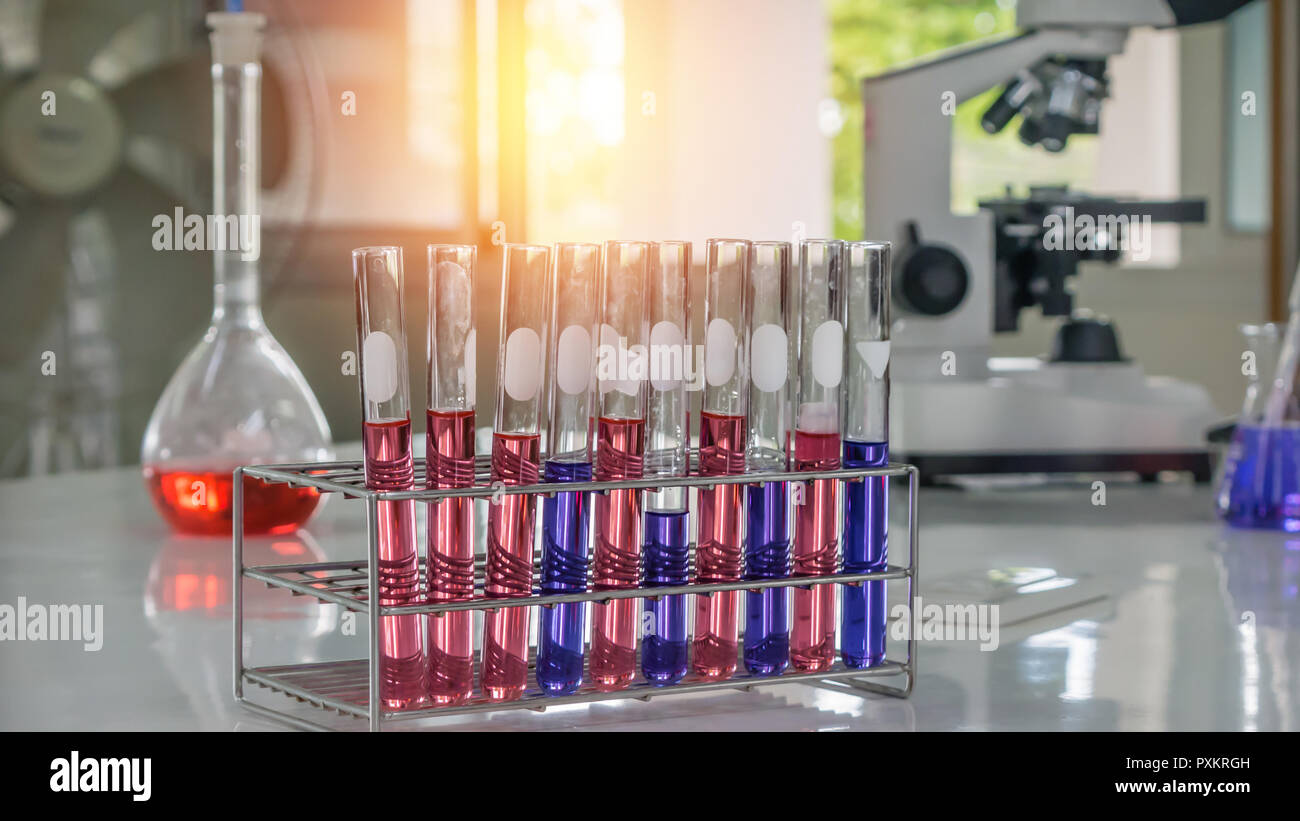 Different laboratory test tubes with colored liquid and with reflection ...