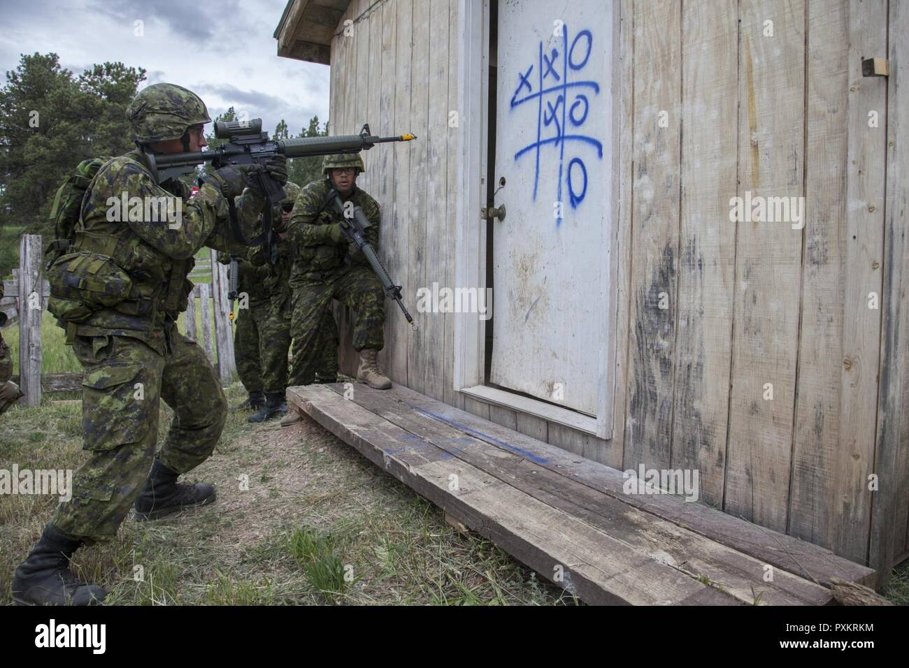 A Soldier of the 3rd Canadian Division, Canadian Army checks a door for ...