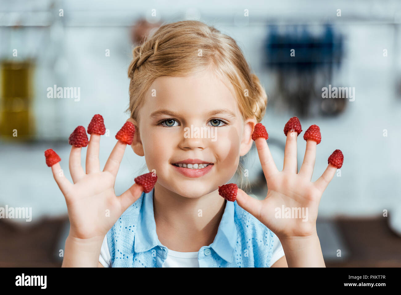 cute happy child with fresh ripe raspberries on fingers smiling at ...