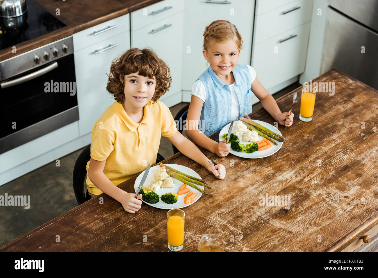 high angle view of cute happy children eating healthy vegetables and ...