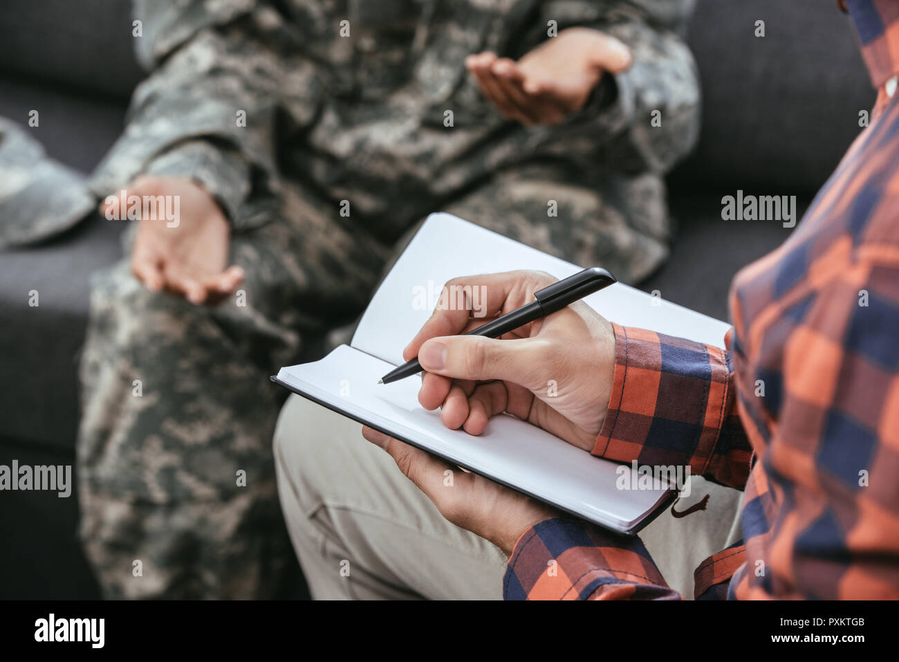 cropped shot psychiatrist writing notes during therapy session with ...