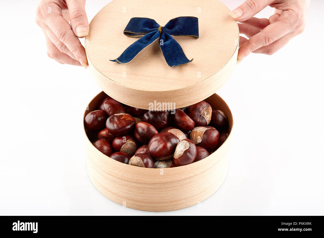 Chestnuts in round wooden box on white background Stock Photo - Alamy